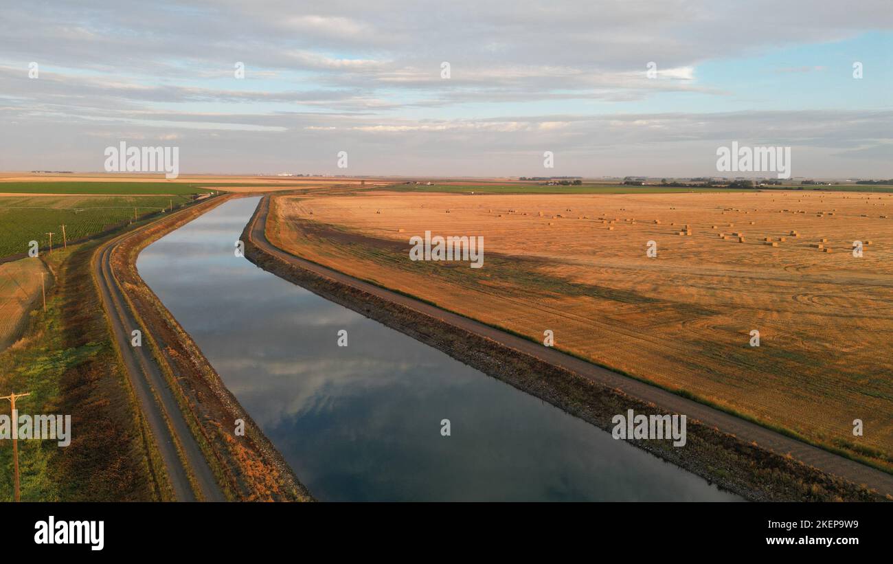 Drone view during sunrise over a farm hay field and river in Alberta ...