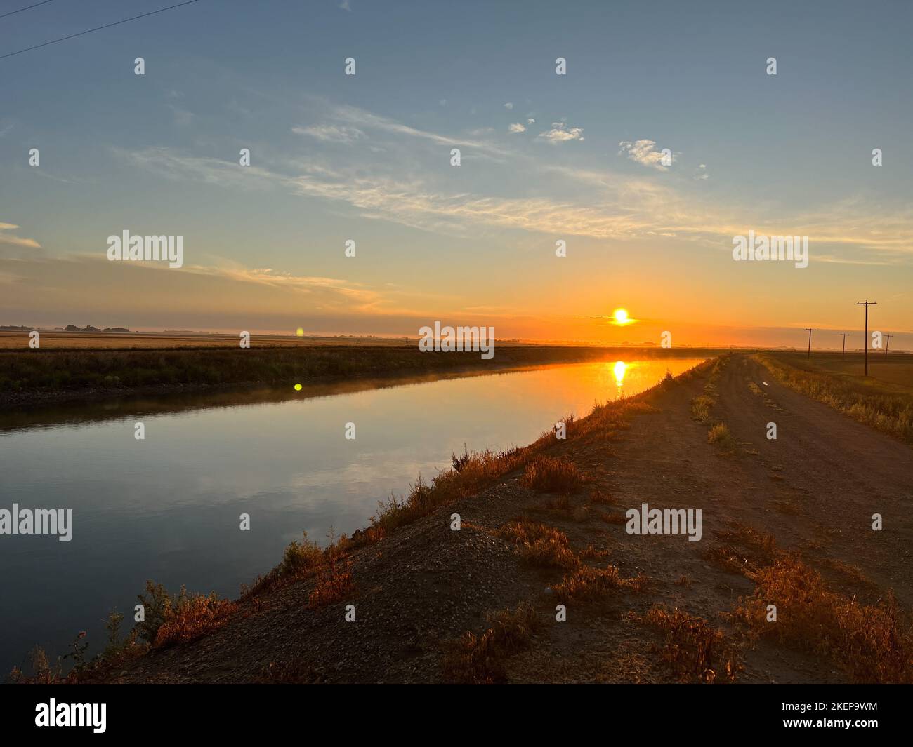 Drone view during sunrise over a farm hay field and river in Alberta ...