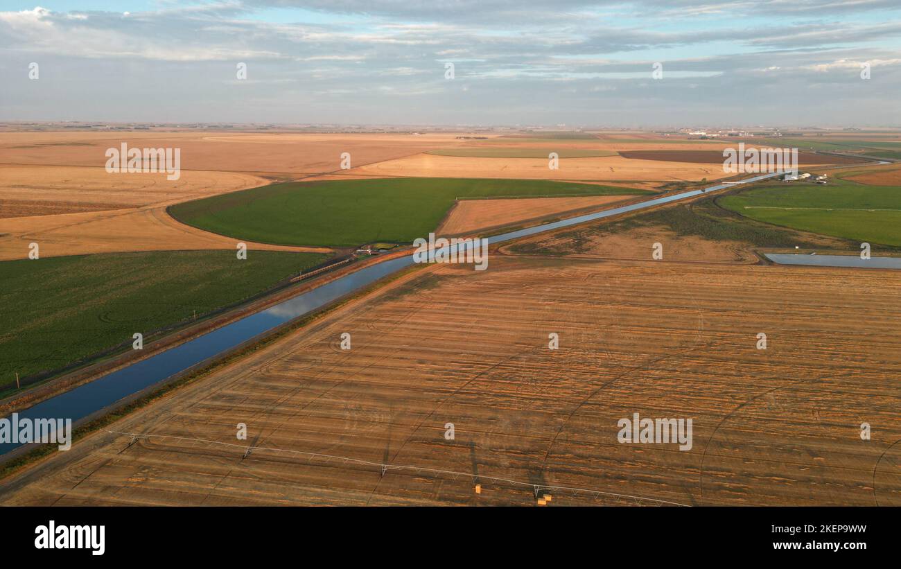 Drone view during sunrise over a farm hay field and river in Alberta ...
