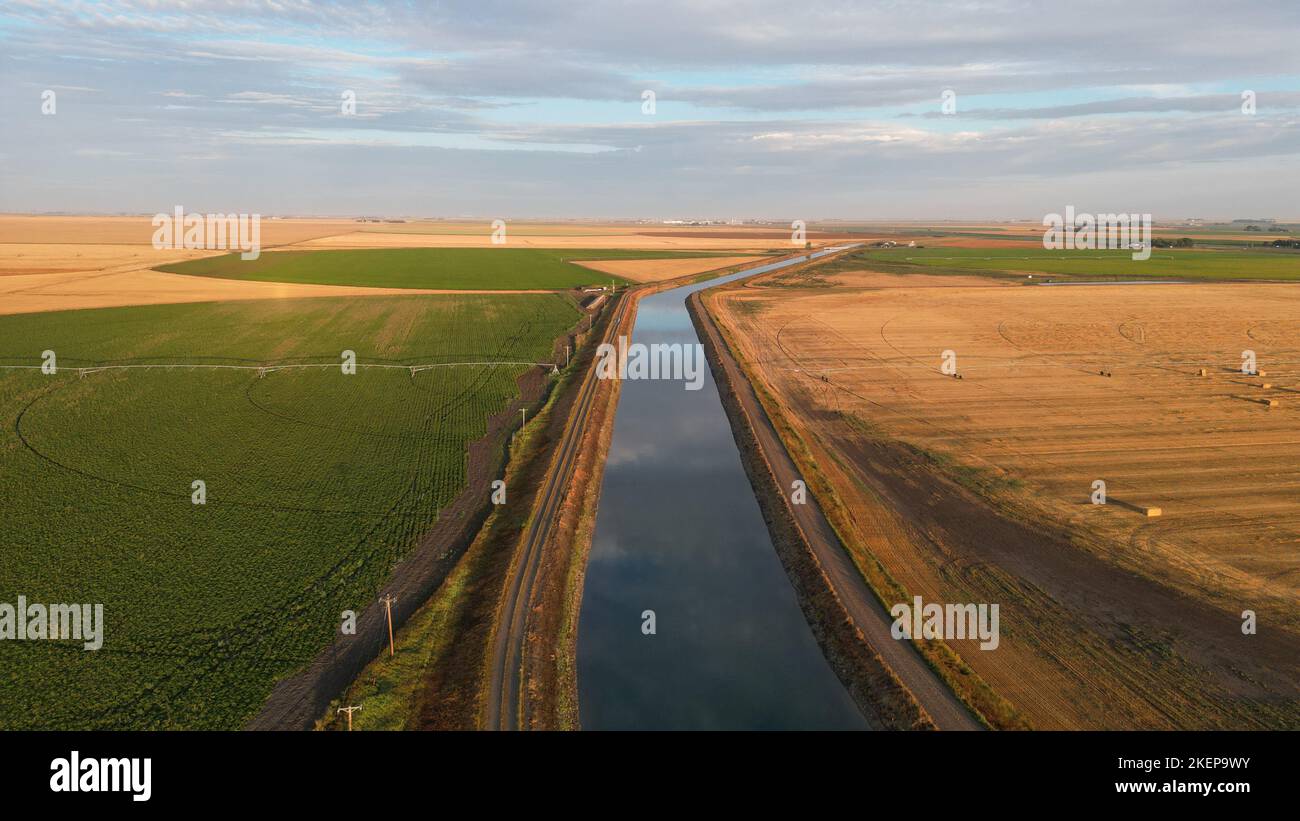 Drone view during sunrise over a farm hay field and river in Alberta ...
