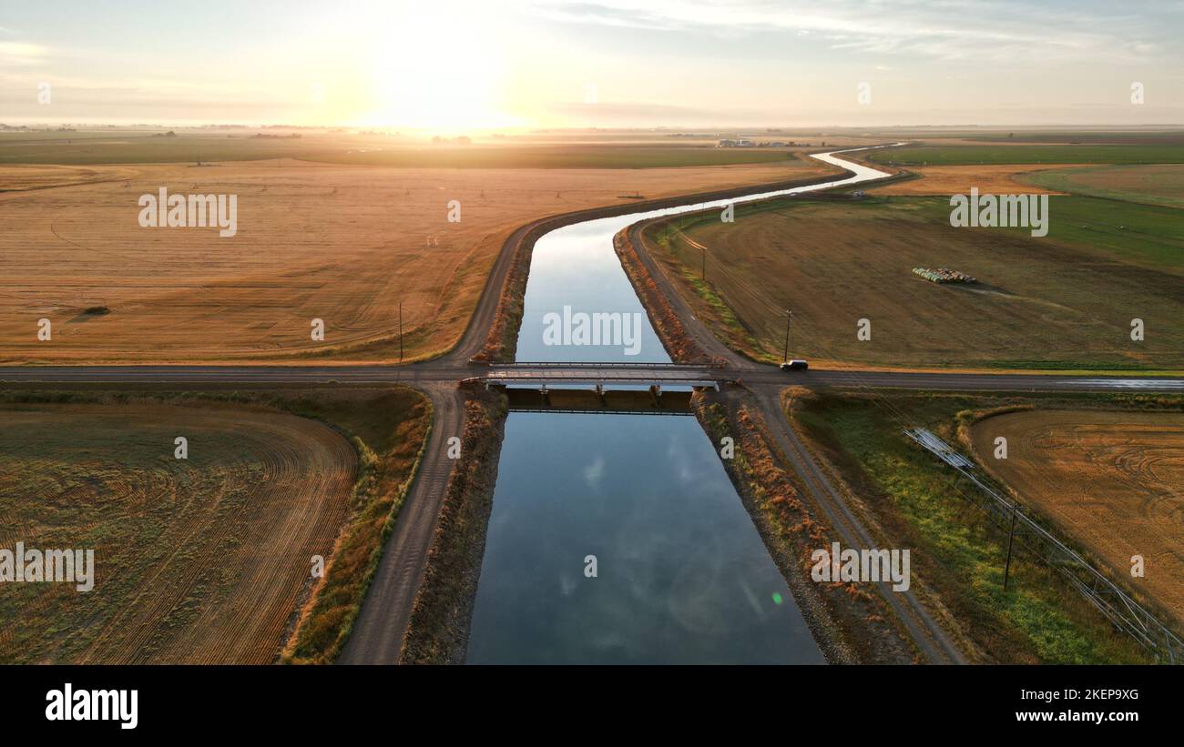 Drone view during sunrise over a farm hay field and river in Alberta ...