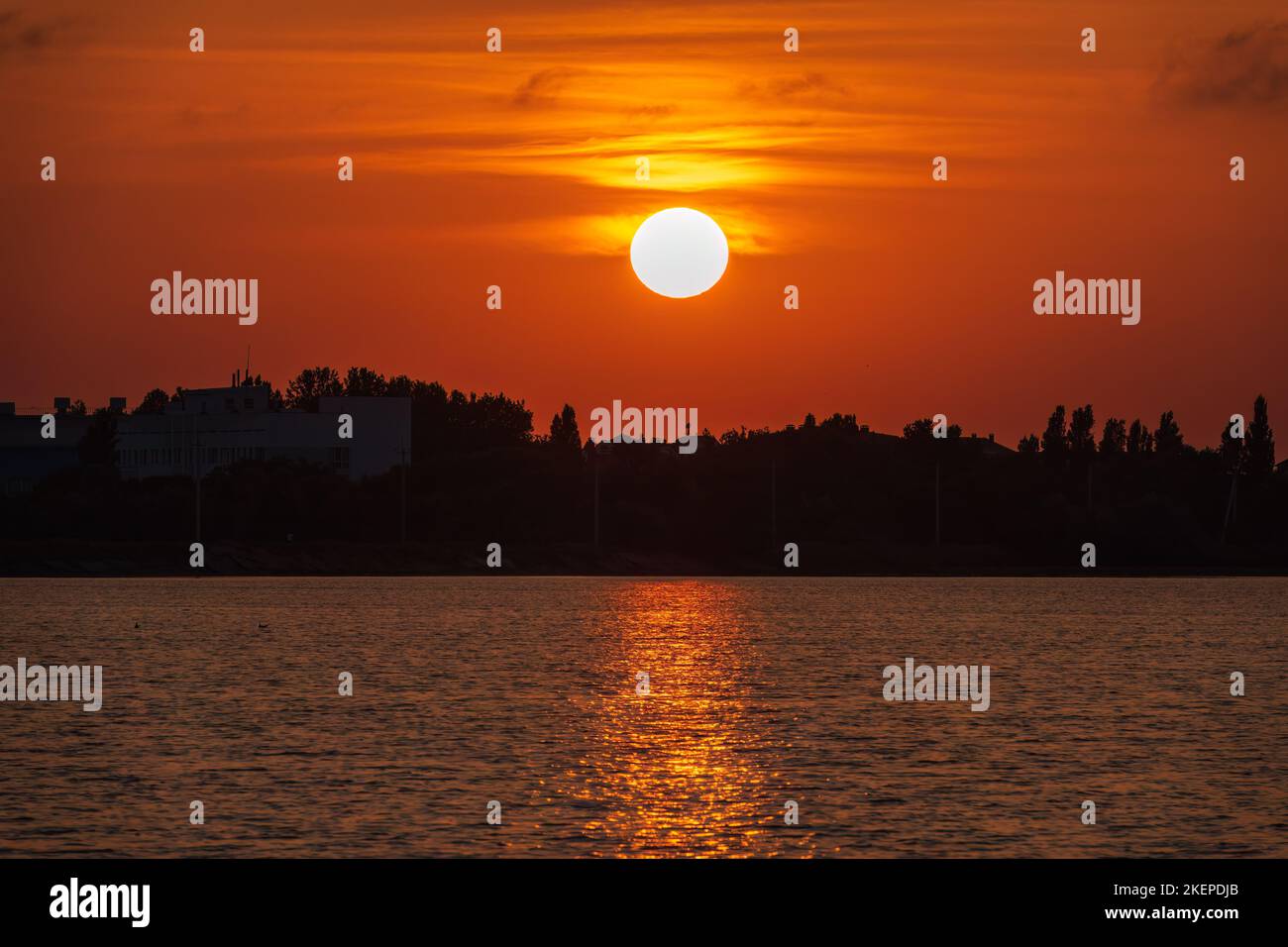 The sun goes down over a lake. Dramatic Sunset Sky Stock Photo - Alamy