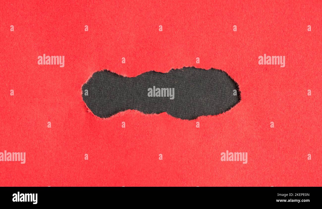 Torn red hole on black background. As template for message or ...