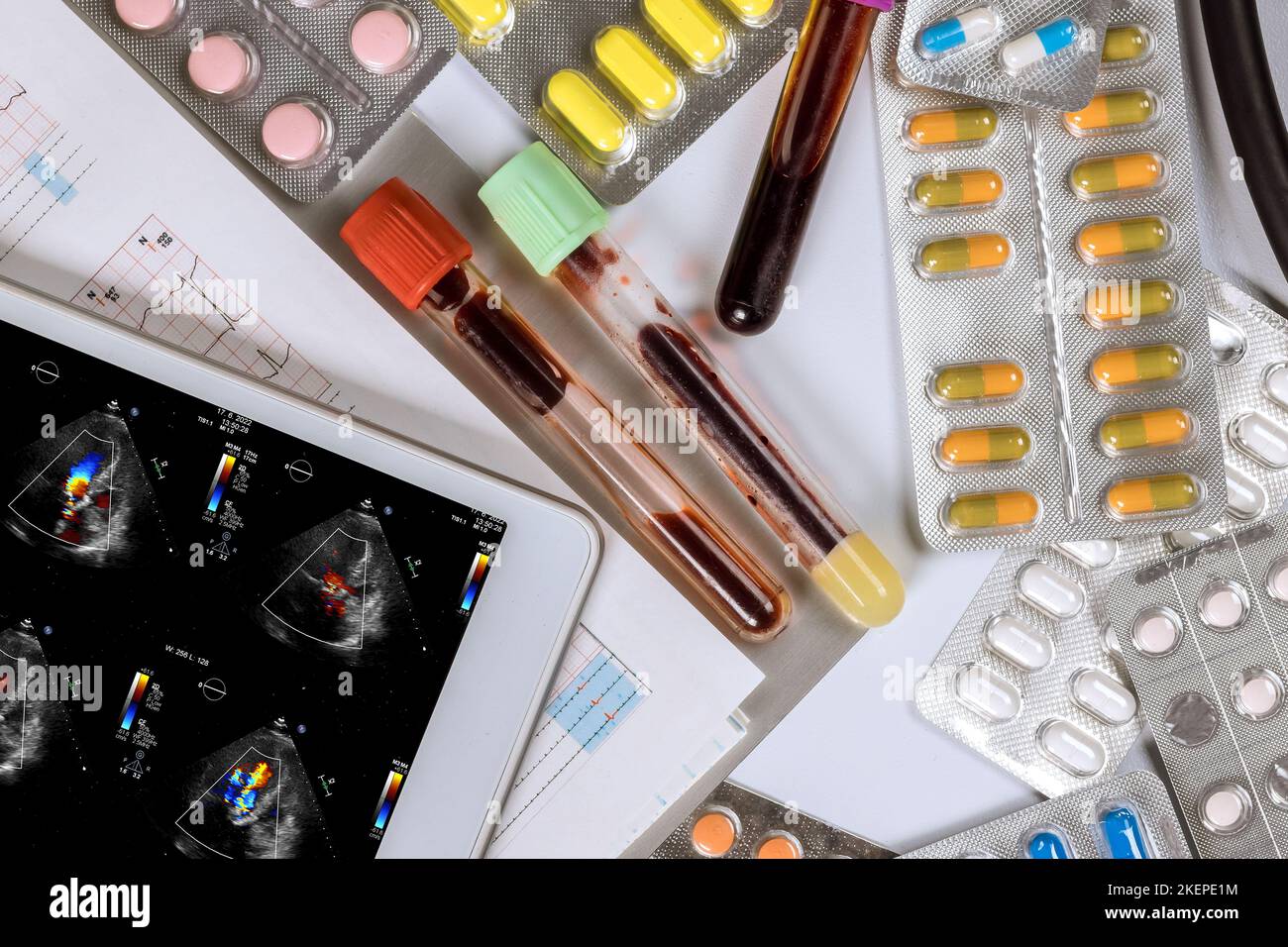 Using a digital tablet device, the doctor checks results of ...