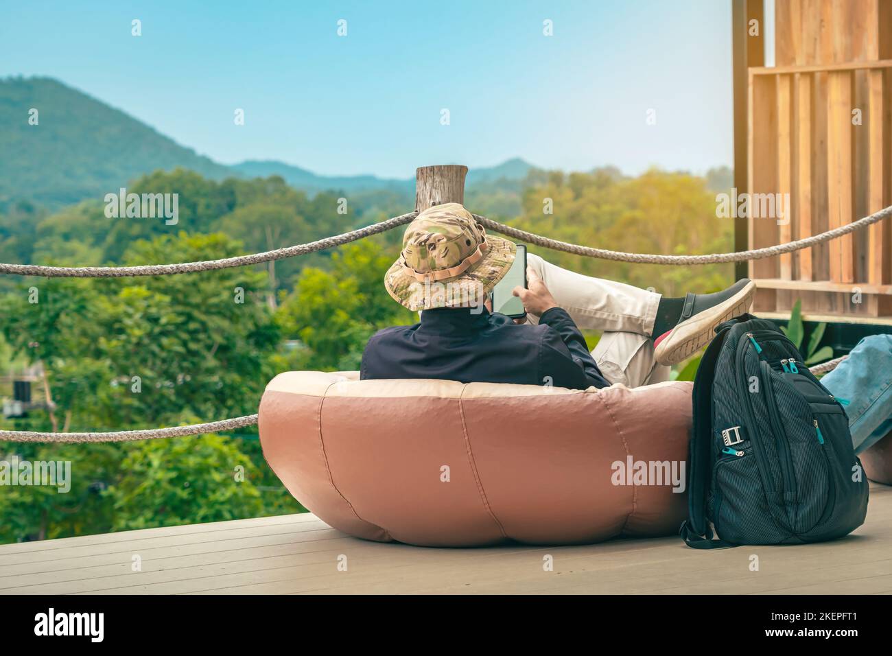 Male tourist wear hat with face mask and his wife use tablet and mobile ...