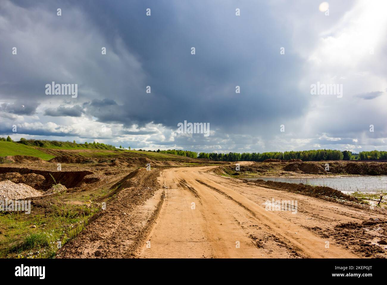 Road embankment for the passage of dump trucks on a sand pit, darkening ...