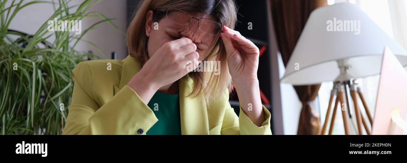 Tired business woman takes off glasses, feeling tired eyes from working ...