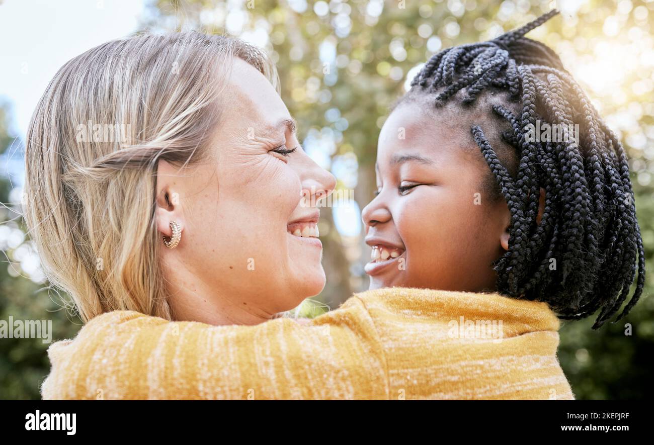 Hug, smile and mother love with girl in a nature park with love, foster care and diversity ...