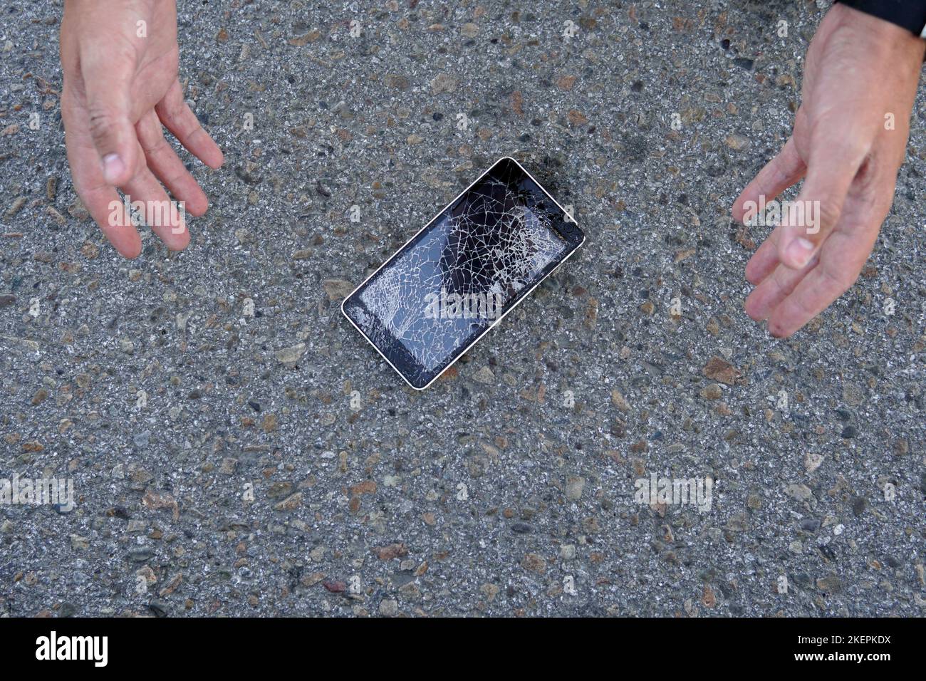 Broken smartphone with cracked screen glass lays on ground. Shocked ...