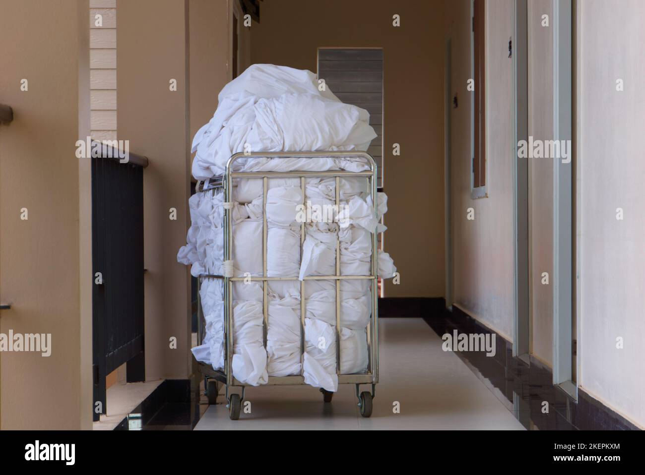 A laundry cart full of dirty linen sits in a hotel corridor in Thailand ...