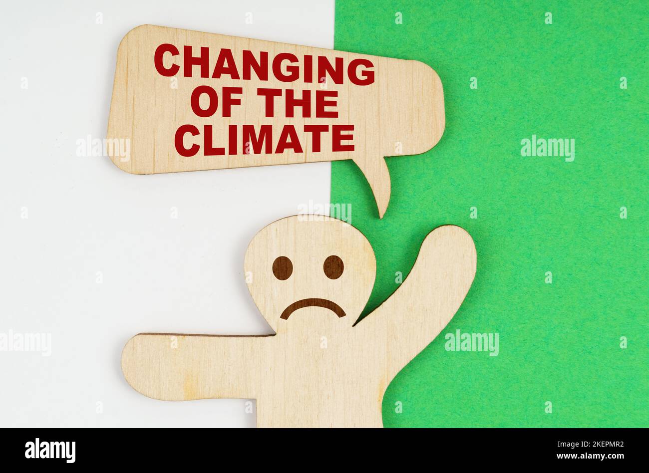 Environmental concept. On a green and white background, a sad wooden ...