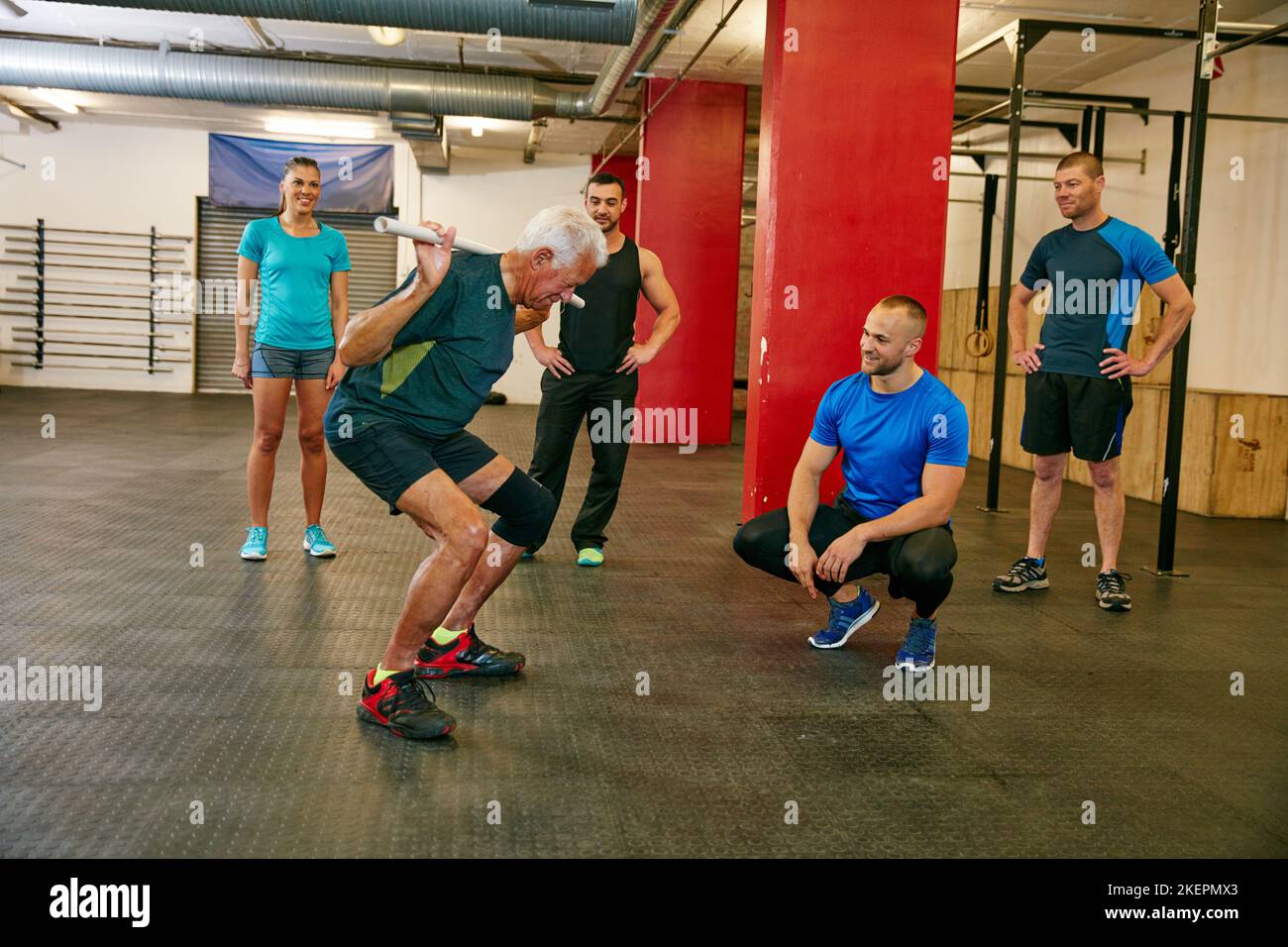 Push your butt back, bend your knees and squat. a senior man doing pvc ...