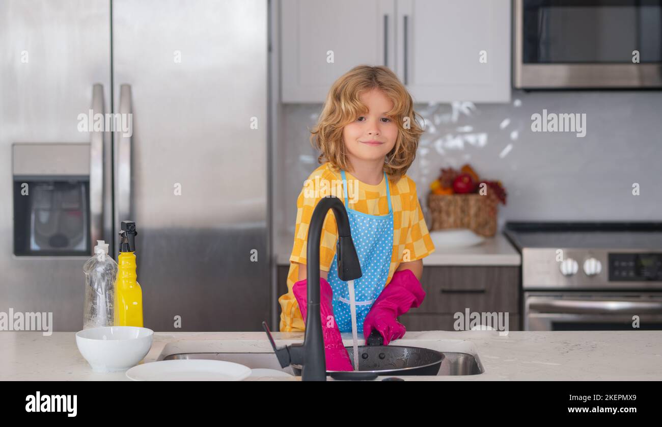Dish washing concept. Child doing and wiping dishes in kitchen. Little ...
