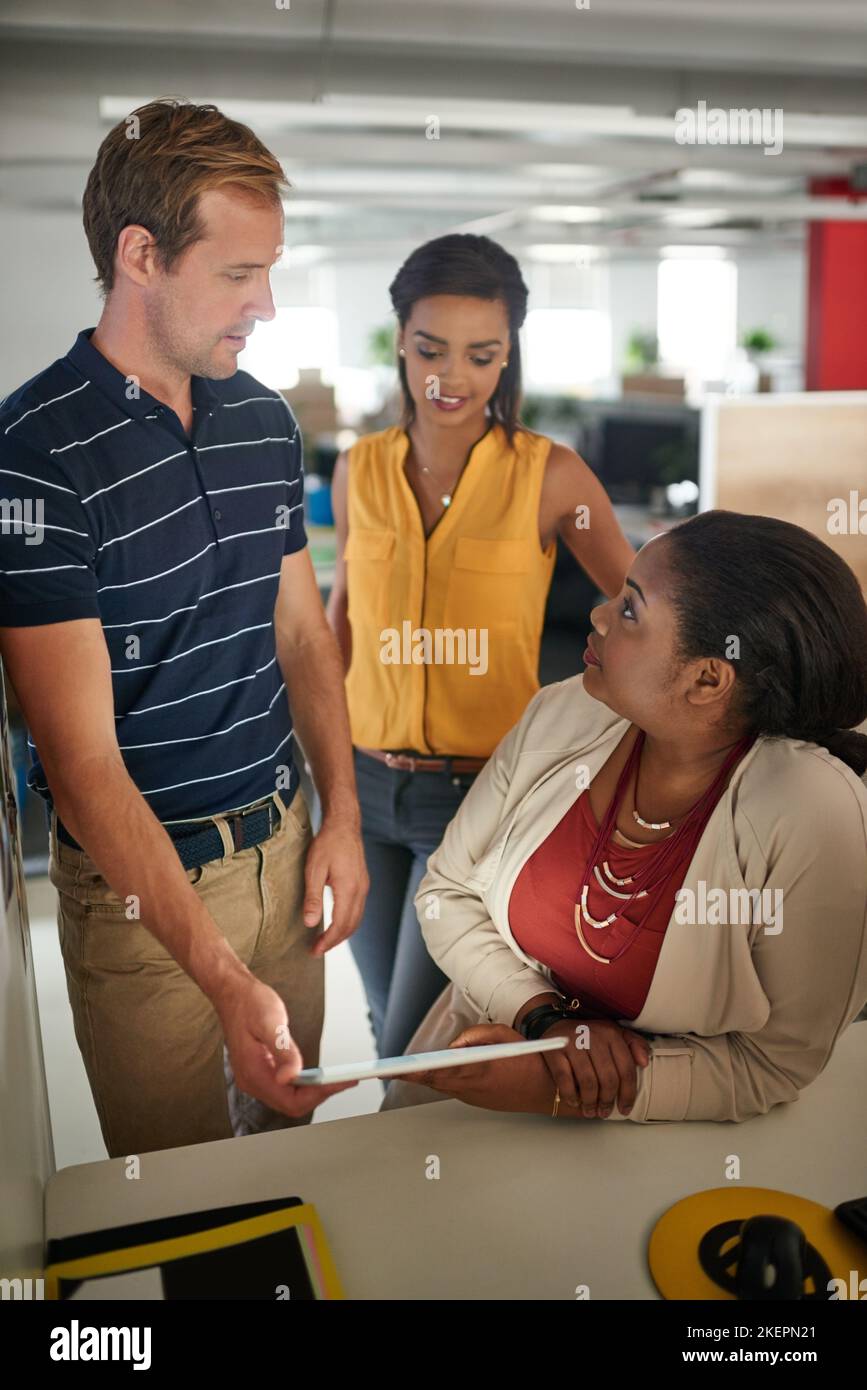 Youre doing great work on this project. a three work colleagues talking ...