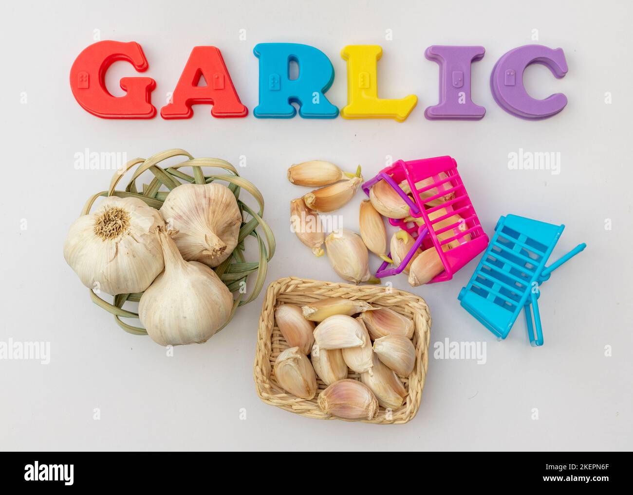 Garlic bulbs and cloves in a miniature baskets with a word GARLIC ...