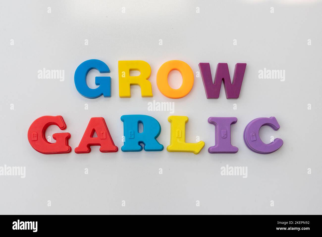 GROW GARLIC text on a magnetic letters on white isolated background ...