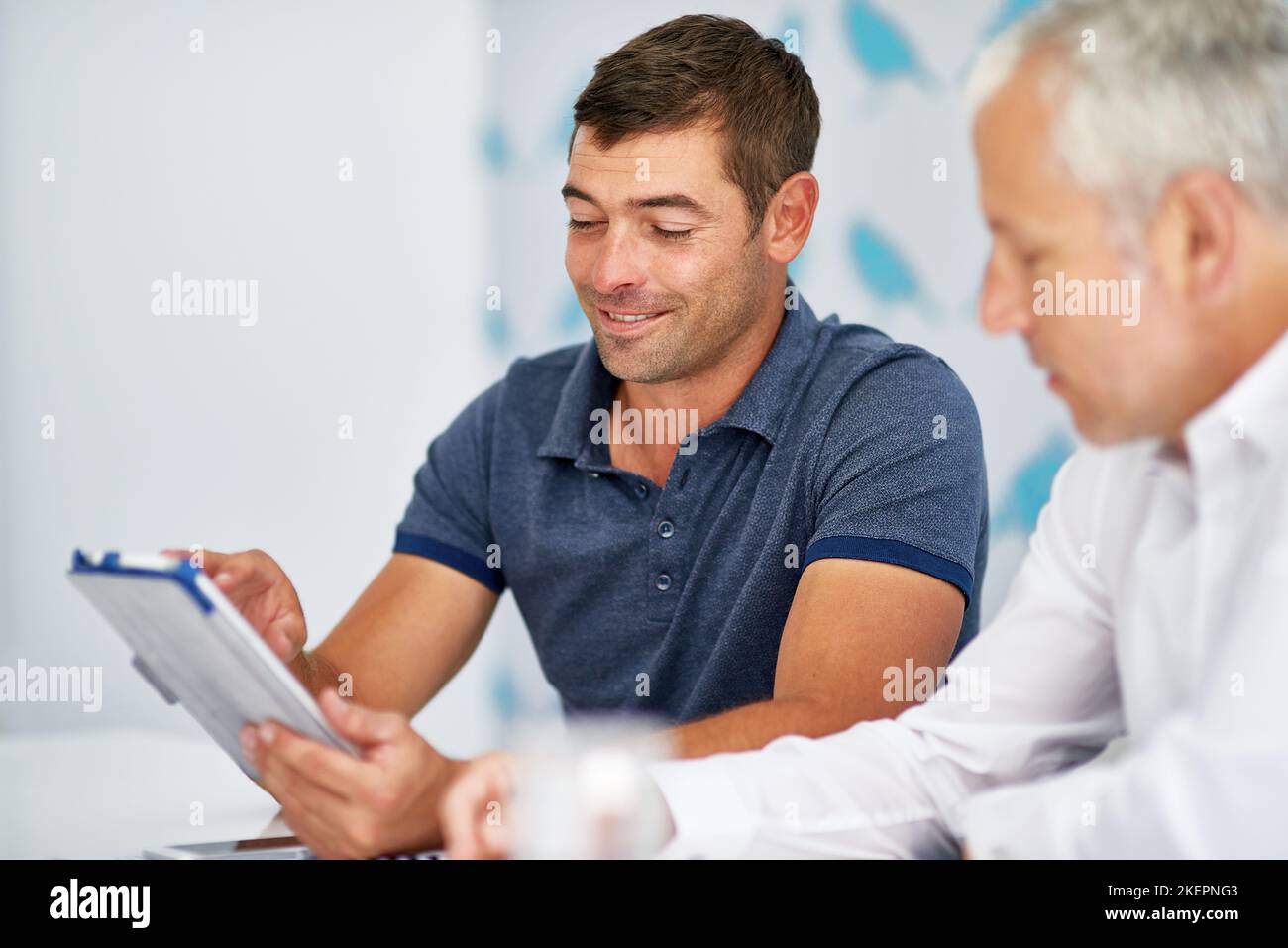 Giving him an update. two men working in the office Stock Photo - Alamy