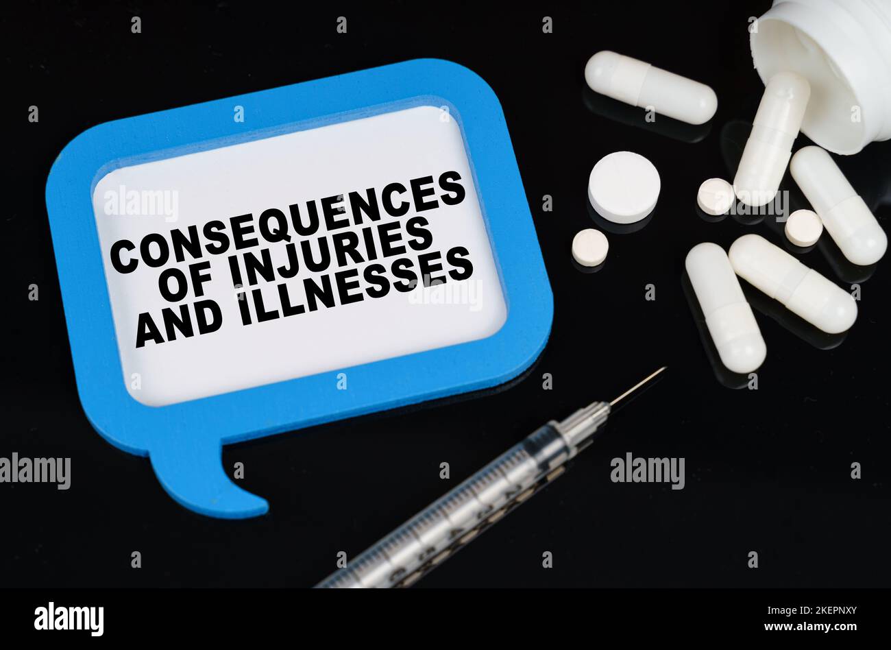 Medical concept. On a black surface, a syringe, pills and a blue frame ...