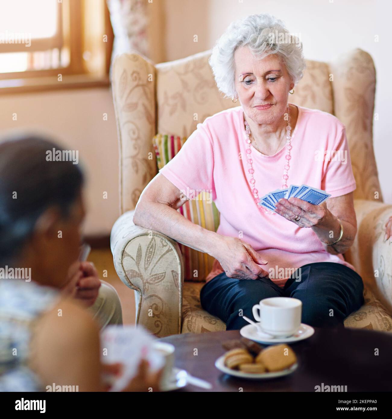 Looking at the cards on the table. seniors playing cards in their ...