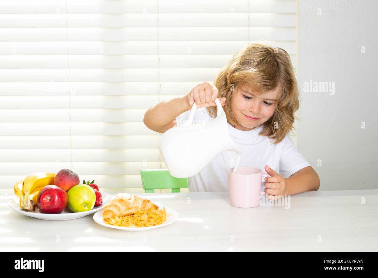 School chil pouring whole cows milk for breakfast. Schoolchild eating ...