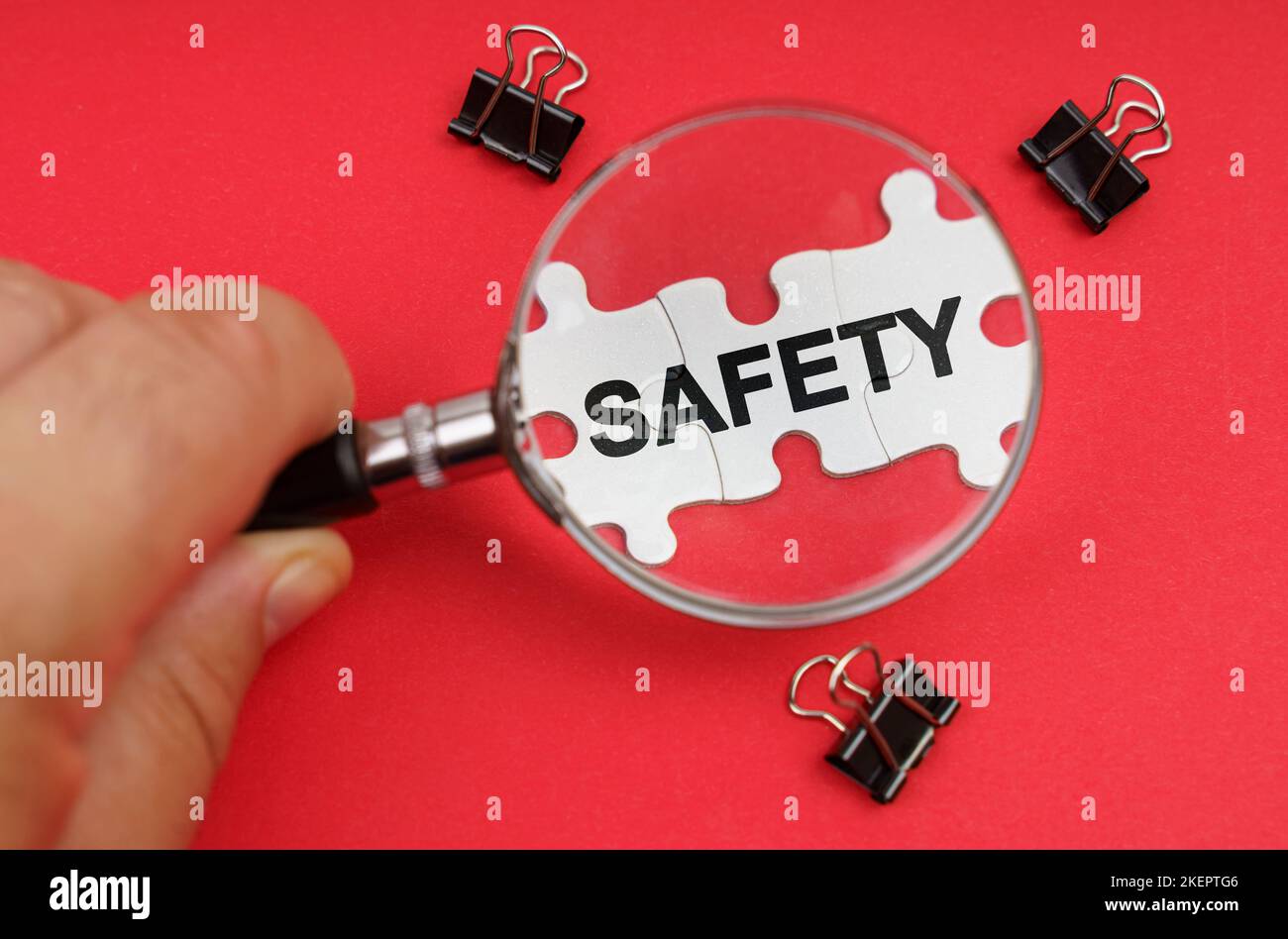 Business concept. A man looks through a magnifying glass at puzzles ...