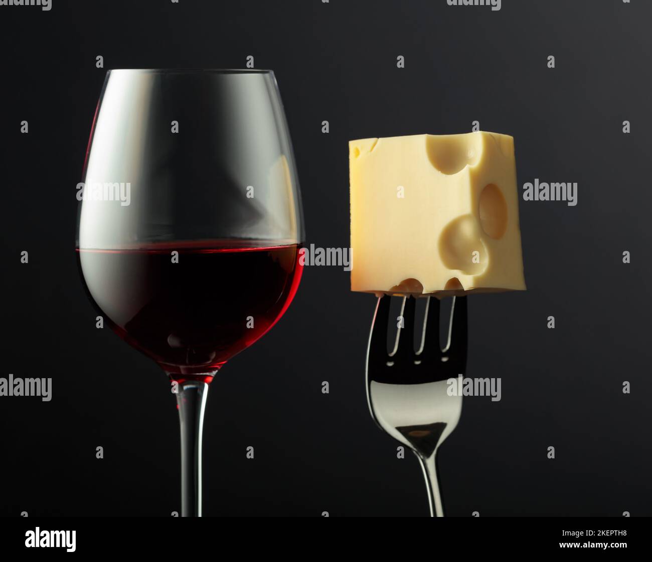 Glass of red wine and Maasdam cheese on a black background Stock Photo ...