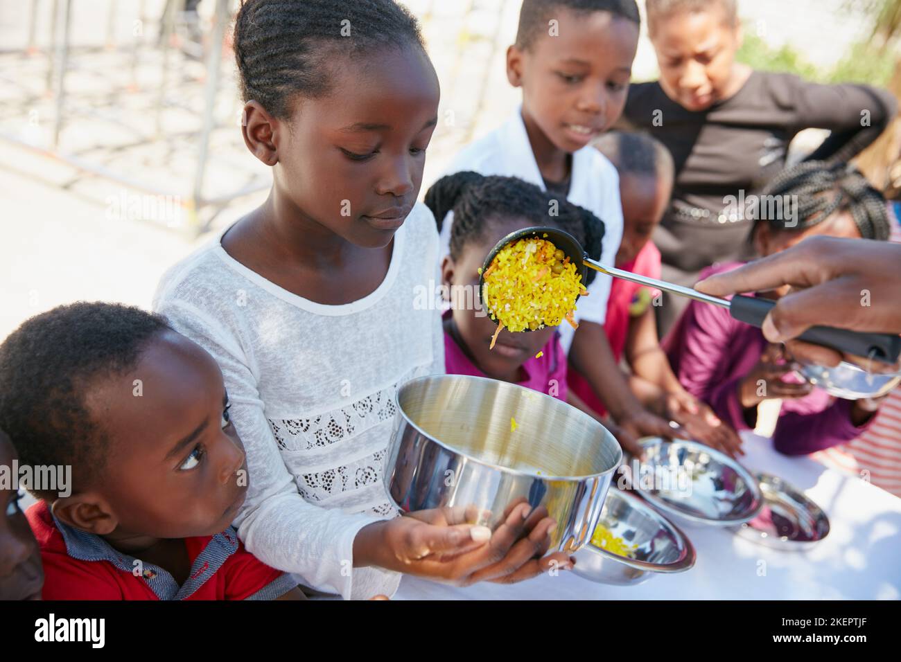 Lunch is served. children getting fed at a food outreach Stock Photo ...