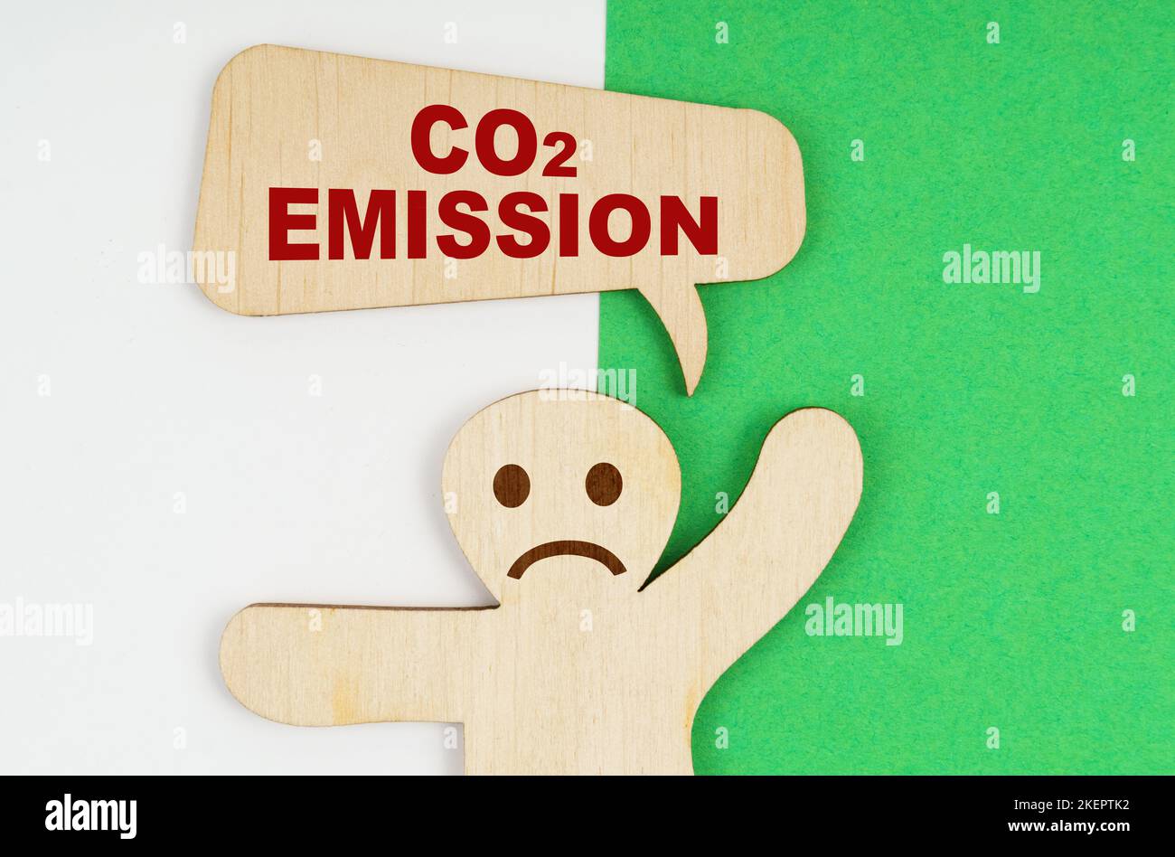 Environmental concept. On a green and white background, a sad wooden ...