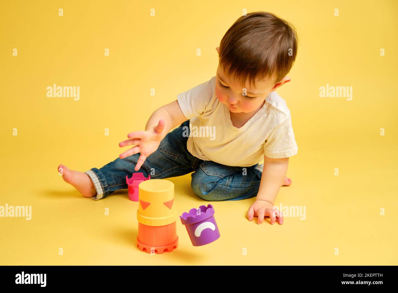 Toddler baby is playing logical educational games with a sandbox mold ...