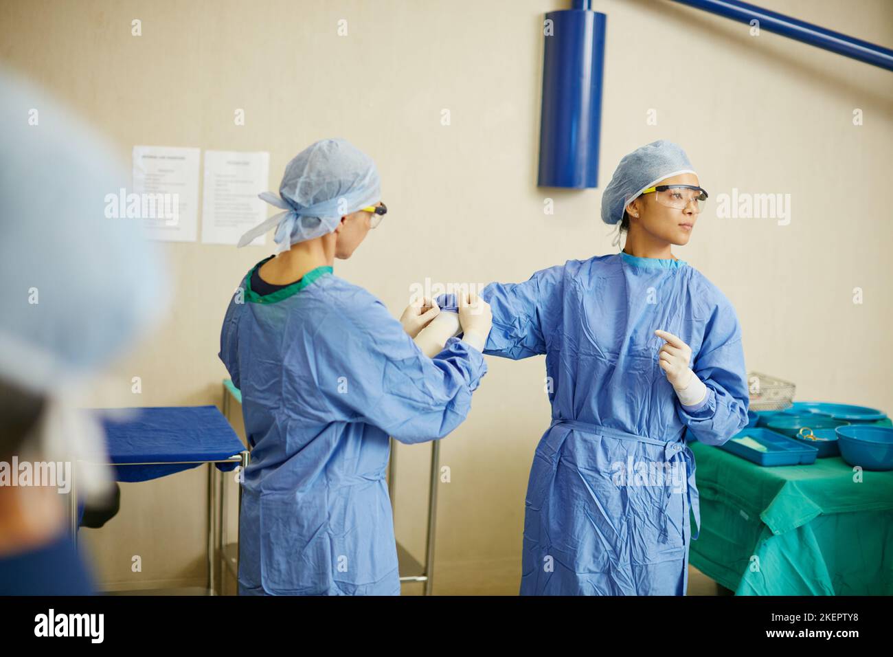 Prepping for surgery as a team. surgeons putting on surgical gloves in ...