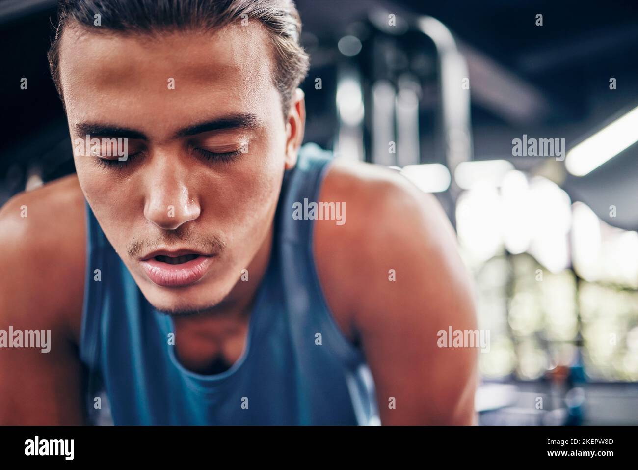 Tired, gym and fatigue man breathing, break and workout, training or ...