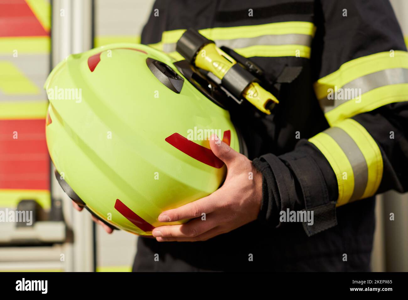 Close up image of a firefighter's helmet. Firefighter holding a yellow ...