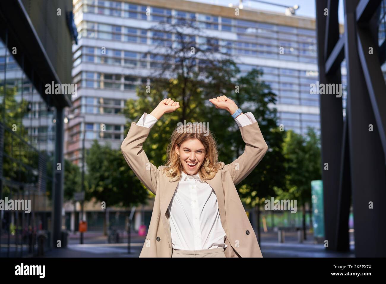 Portrait of happy young businesswoman lift hands up, does fist pump ...
