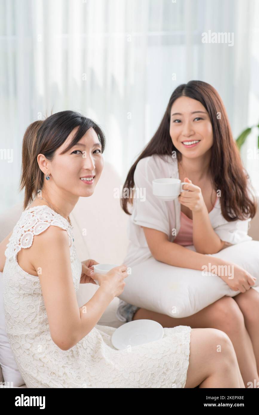 Two Korean young women drinking tea and gossipping at home Stock Photo - Alamy