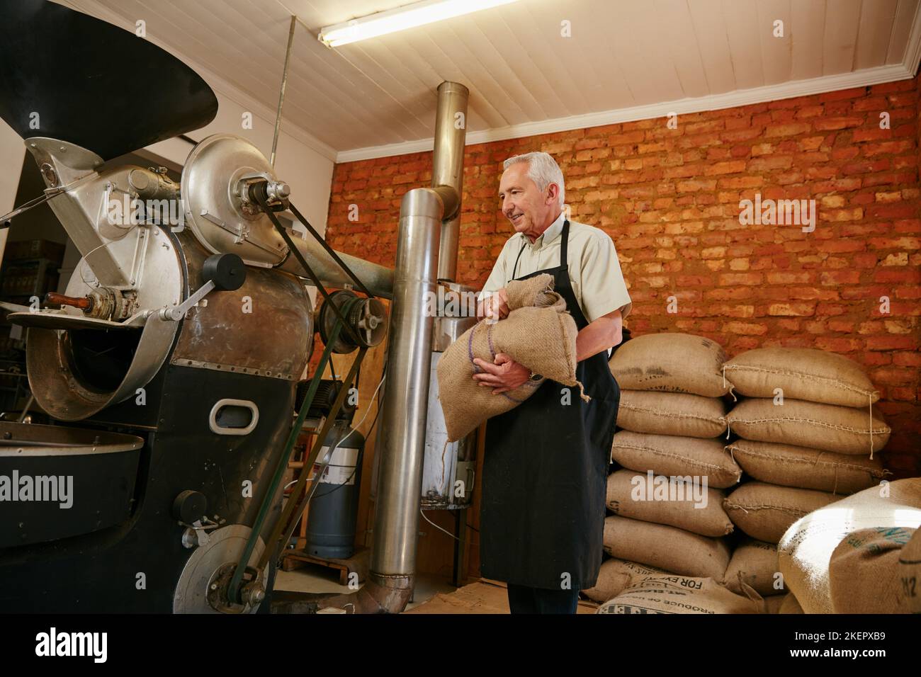 Ready to be roasted. a senior man working in a roastery Stock Photo - Alamy