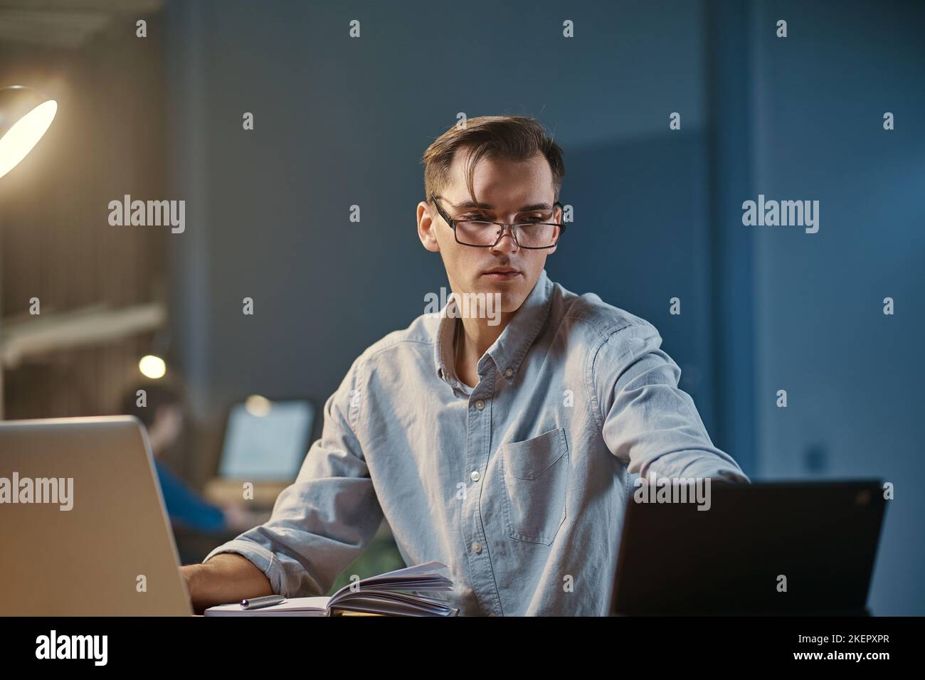 young employee works overtime in the office at night Stock Photo - Alamy