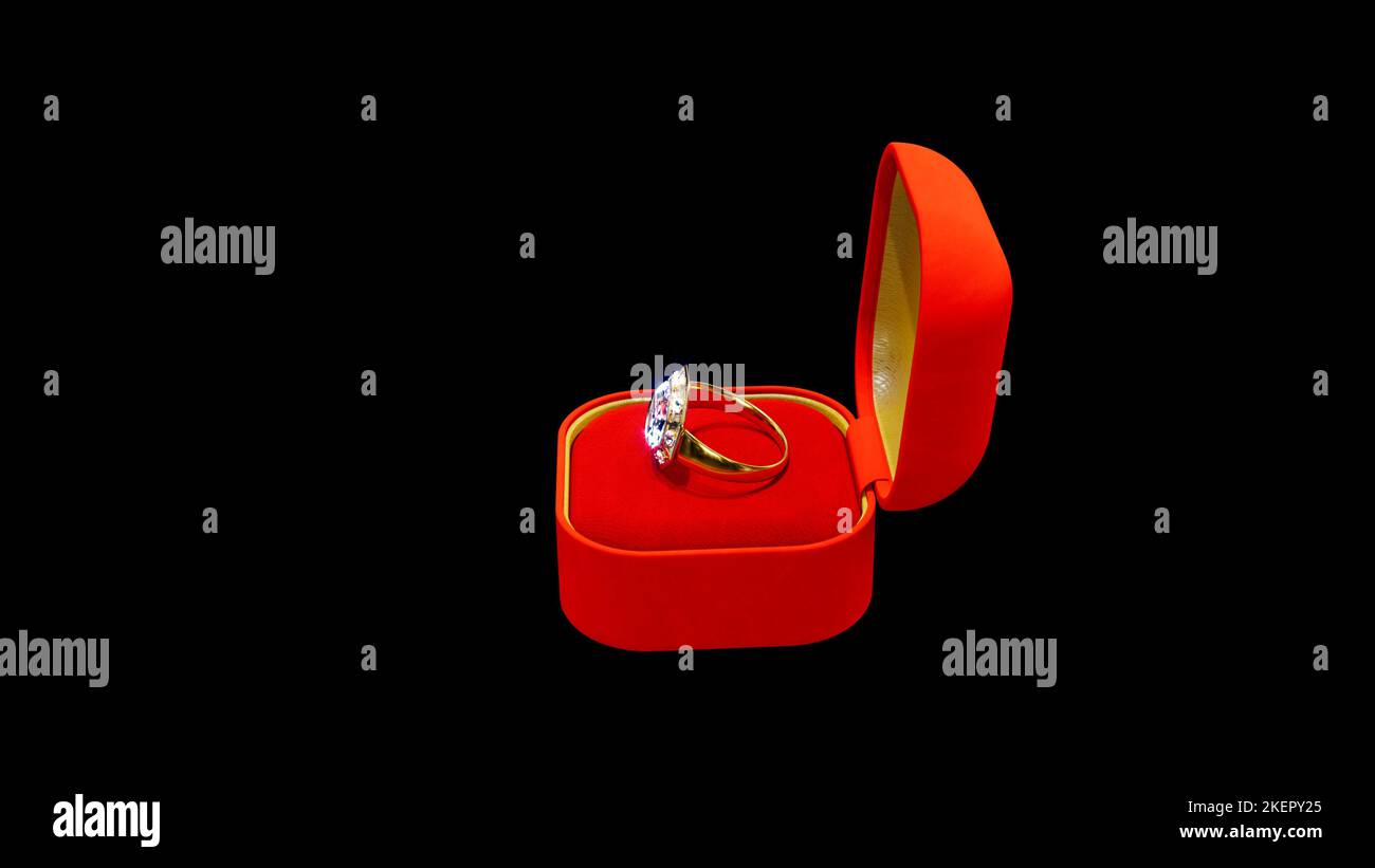 Red - goldish opened jewellery present with diamond wedding ring on ...