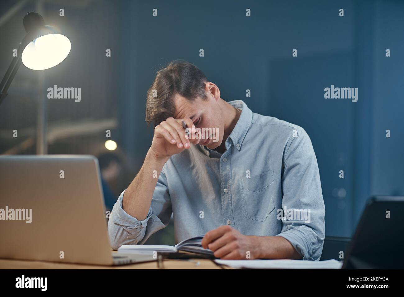 tired young businessman taking notes in his notebook Stock Photo - Alamy