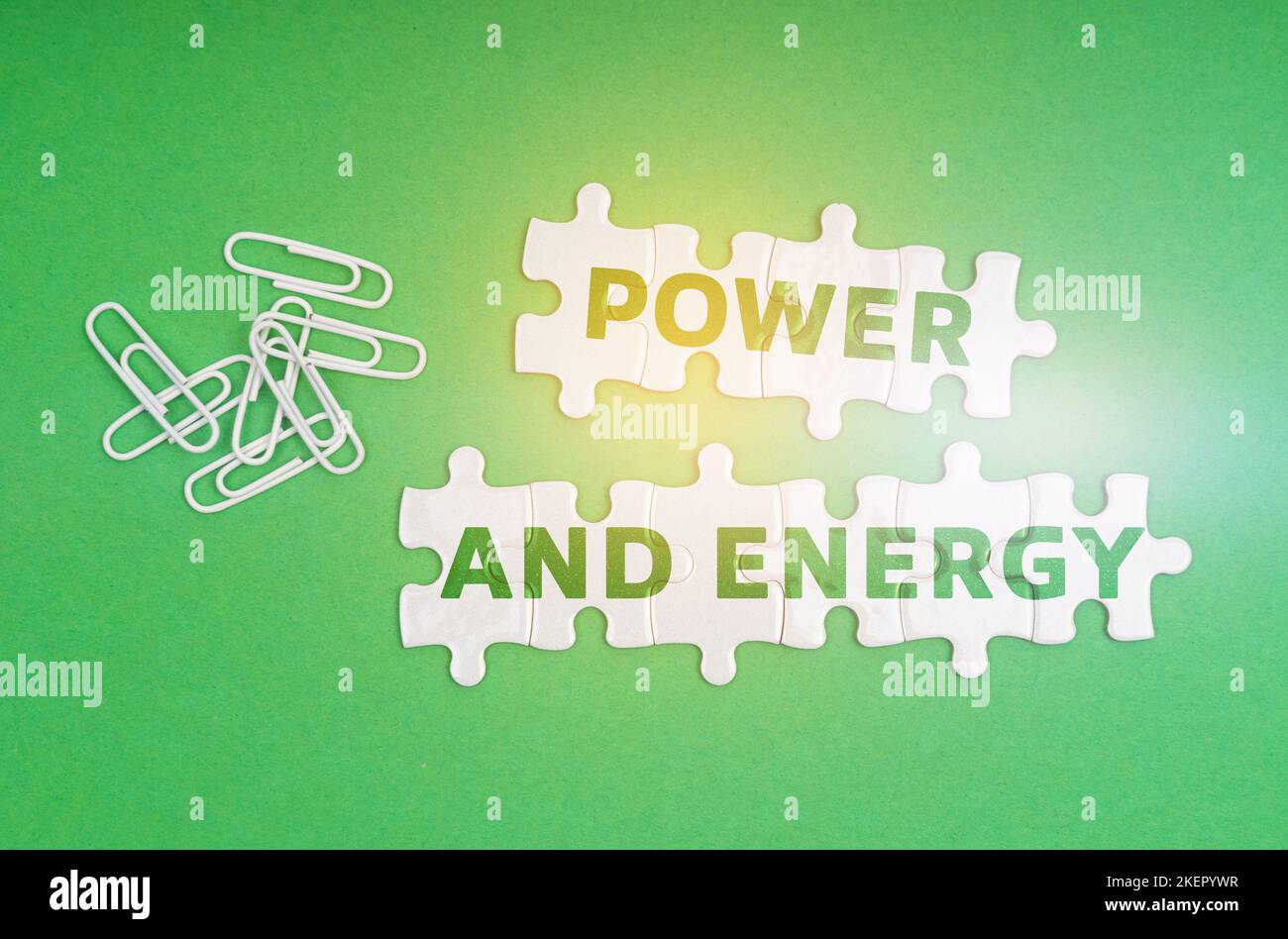 Ecology concept. On a green background, paper clips and white puzzles ...