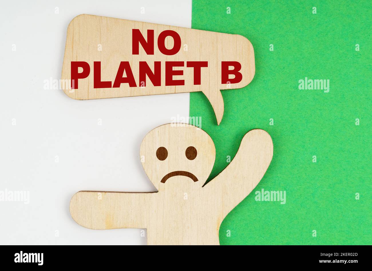 Environmental concept. On a green and white background, a sad wooden ...