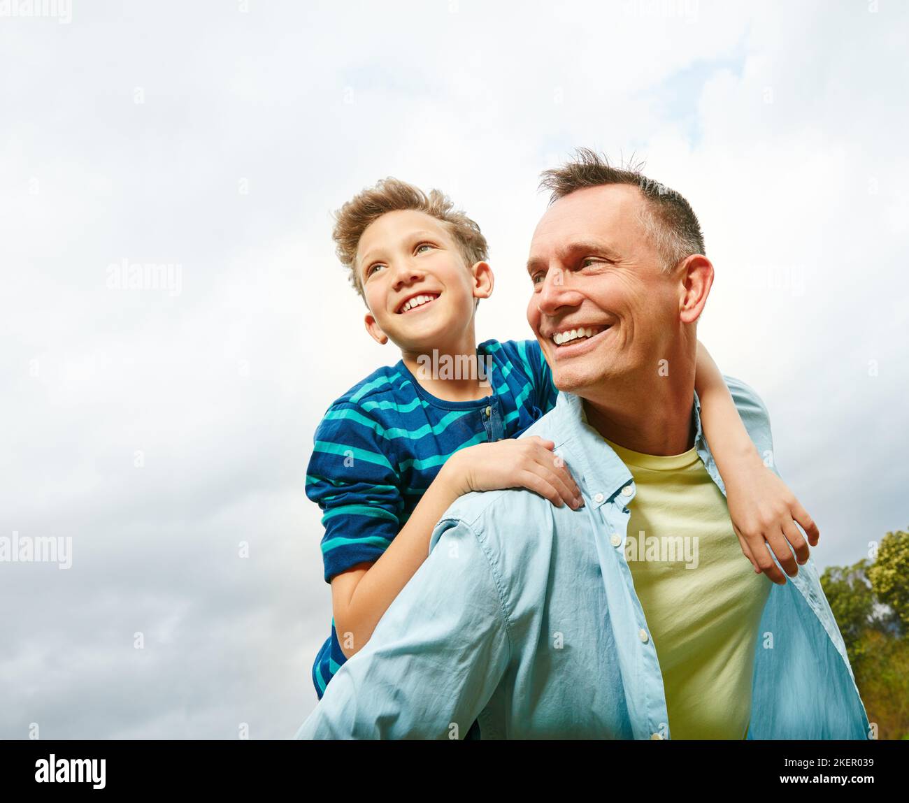 He always has time for his boy. a dad giving his son a piggyback ...