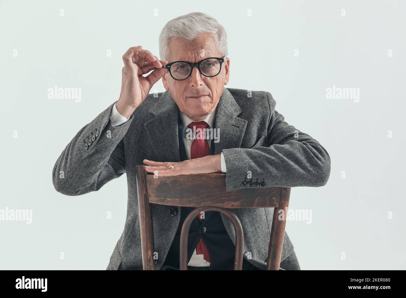 curious old man with grizzled hair adjusting glasses and trying to see ...