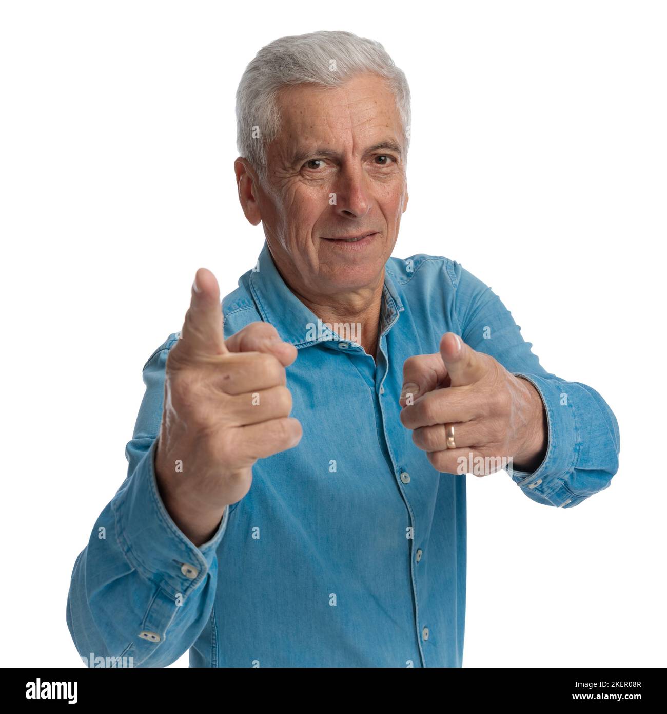 portrait of good looking old man in denim shirt being cool and pointing ...