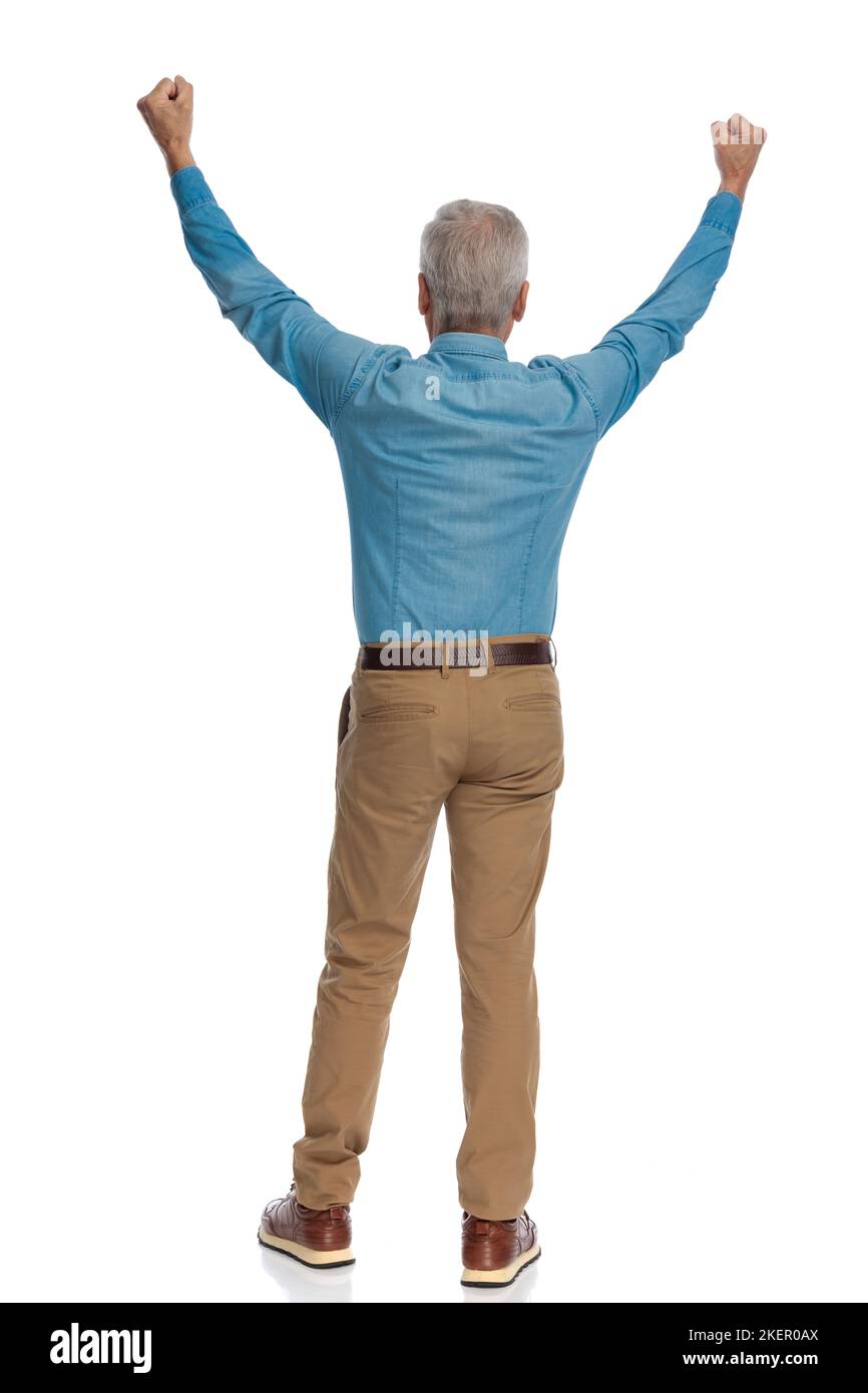 back view of old man with grey hair holding fists above head and ...