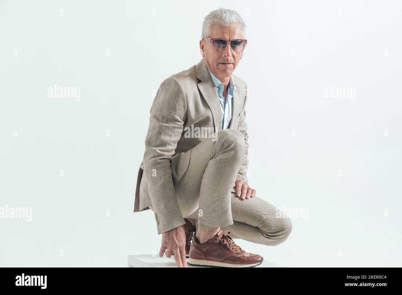 good looking guy with grey hair in his 60s crouching and posing with ...