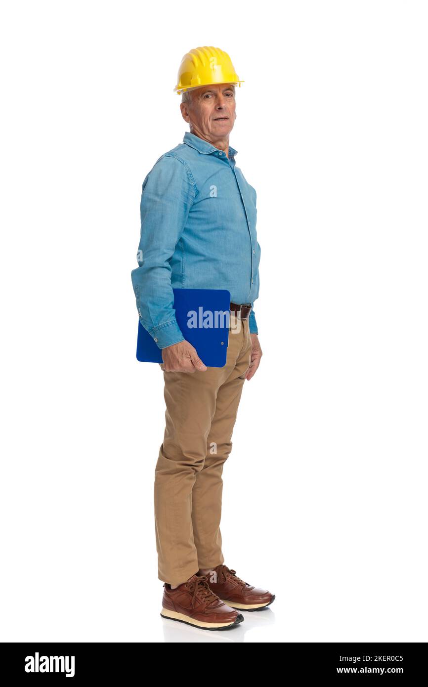 side view of serious old engineer in his 60s with yellow safety hat ...