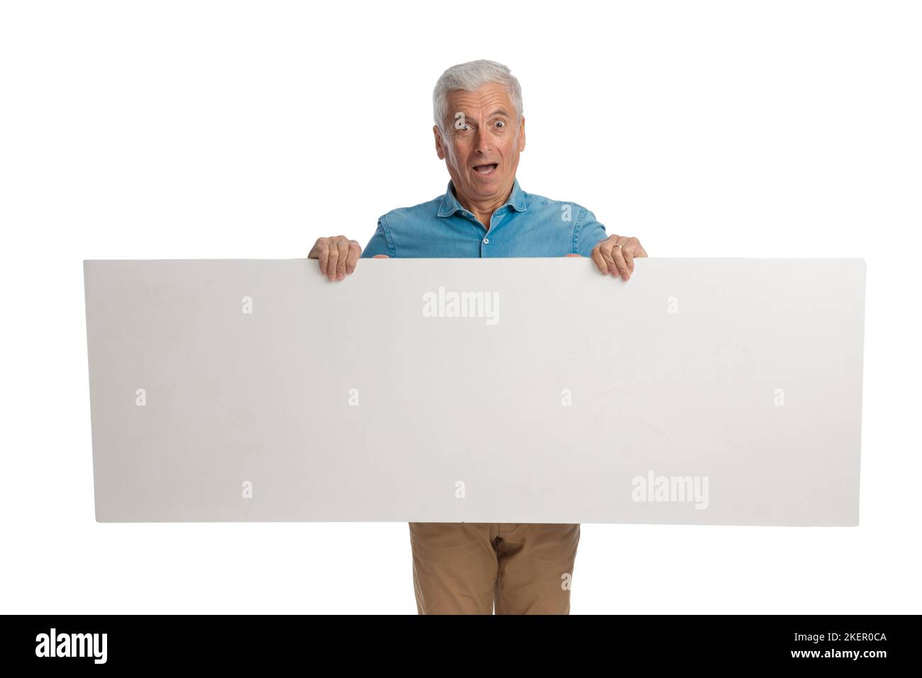 surprised old man holding empty white board and showing it while ...