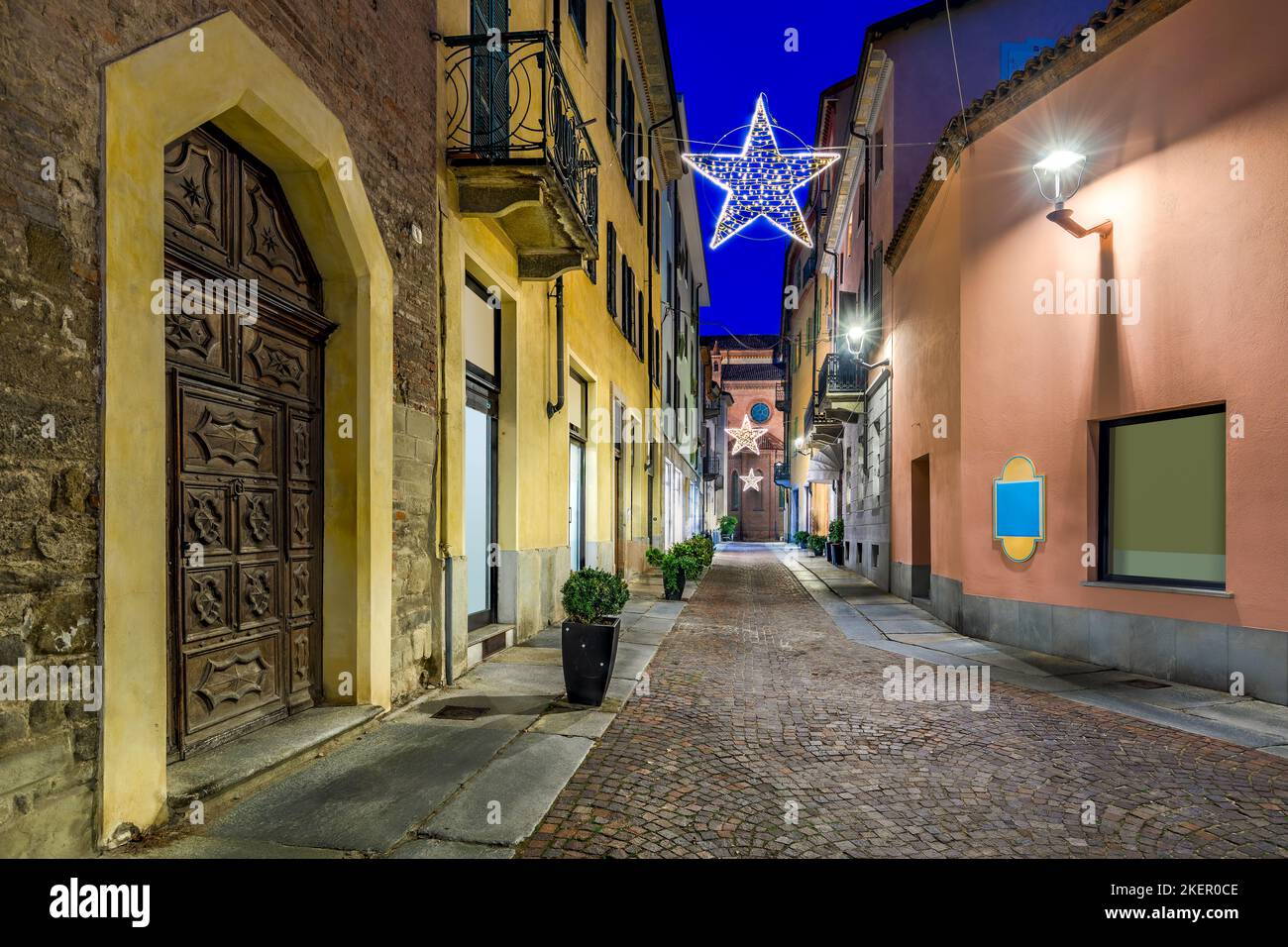 Narrow cobblestone street in old town of Alba illuminated with ...