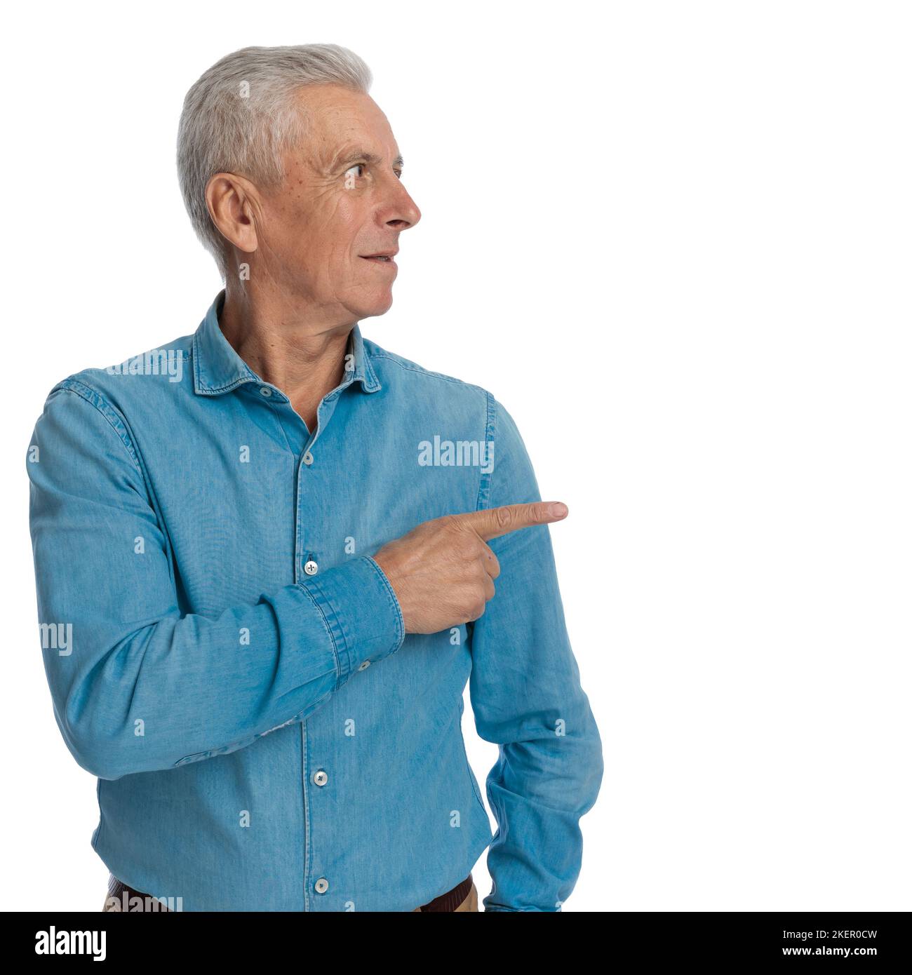 portrait of curious old guy in casual jeans shirt looking and pointing ...