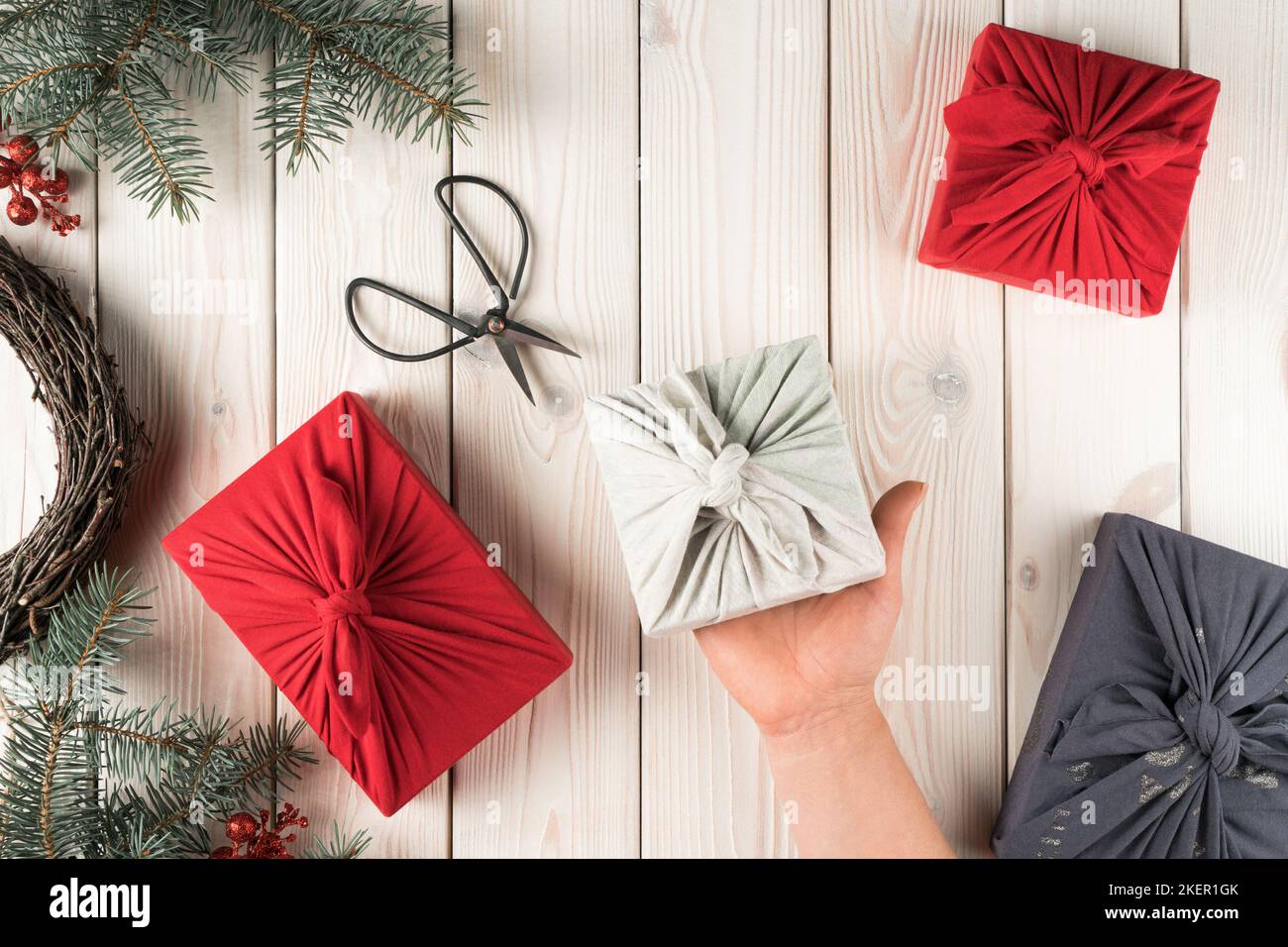 Human hand hold christmas present in furoshiki package, top view ...